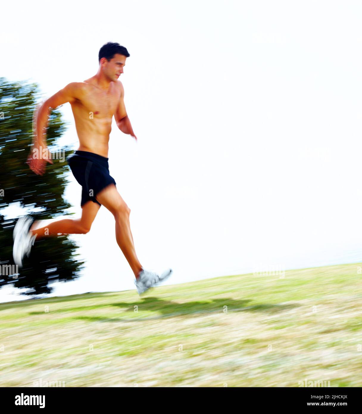 Muscular young man running outdoors - Copyspace. Portrait of a muscular ...