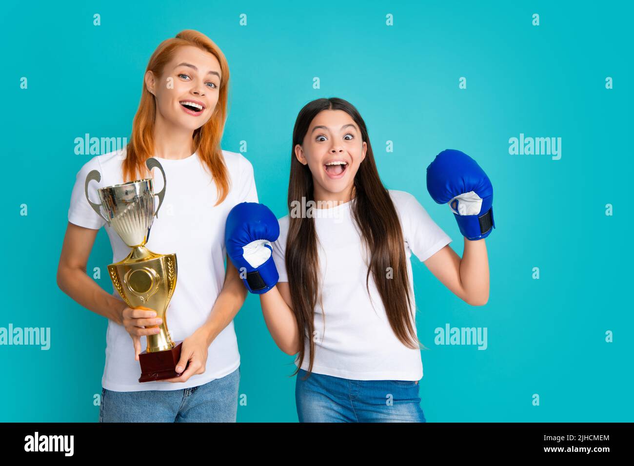 Mommy and teen daughter in boxing gloves holding winning prize, showing ...