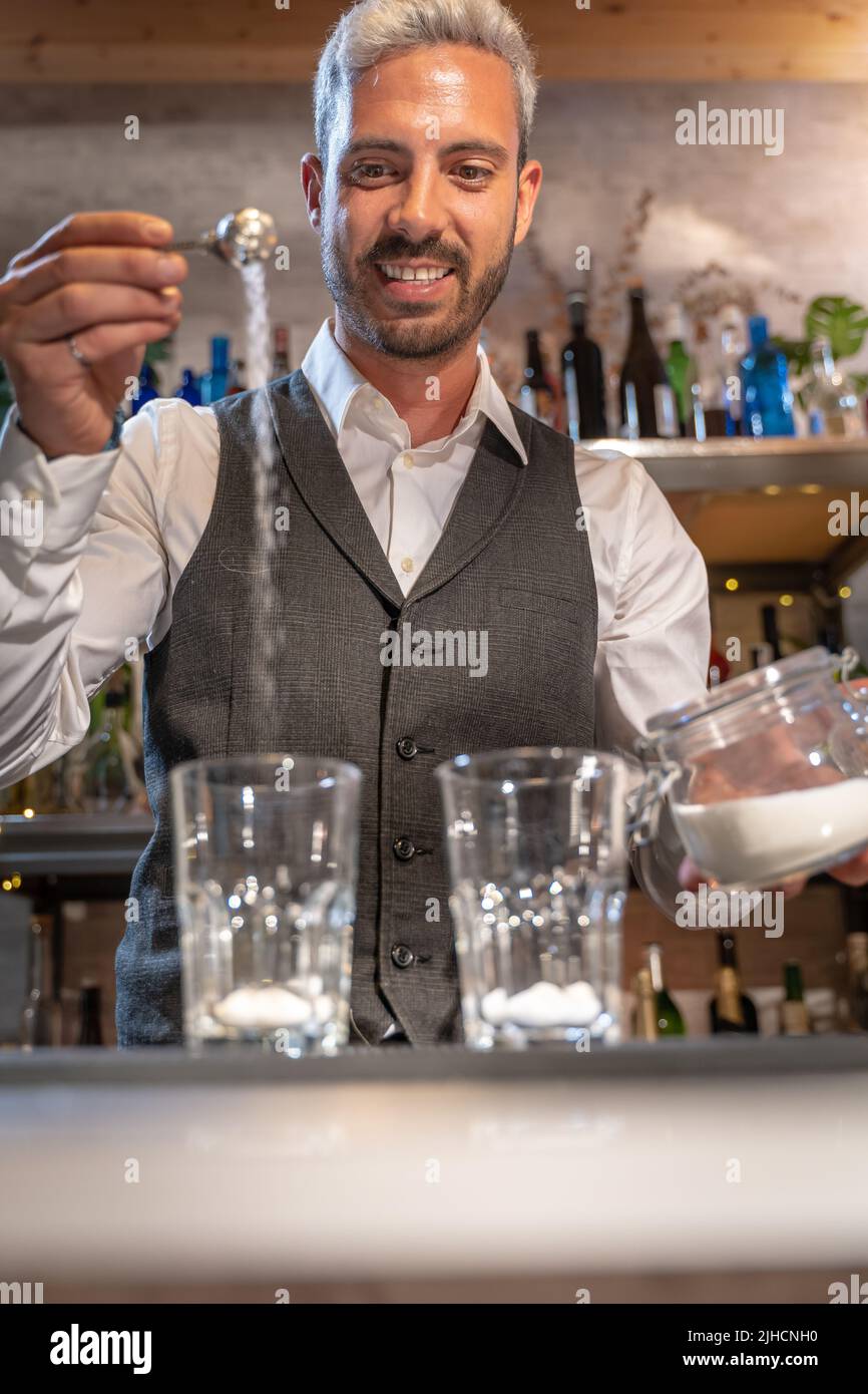 Barman making cocktail Mojito in night club adding ingredients and ...