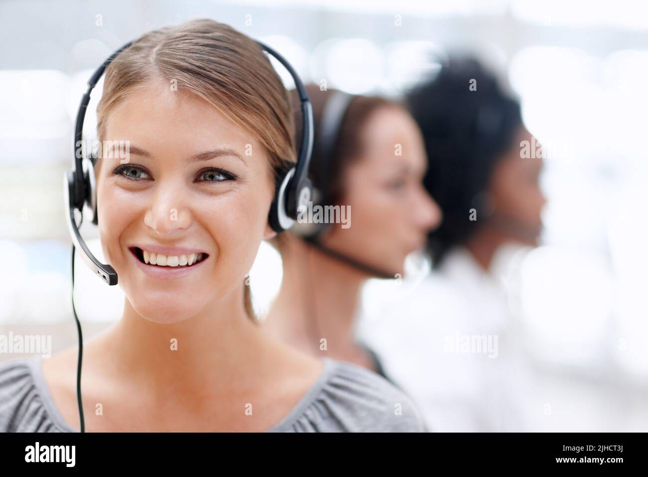 Giving the best service she can. Happy call operator wearing a headset ...