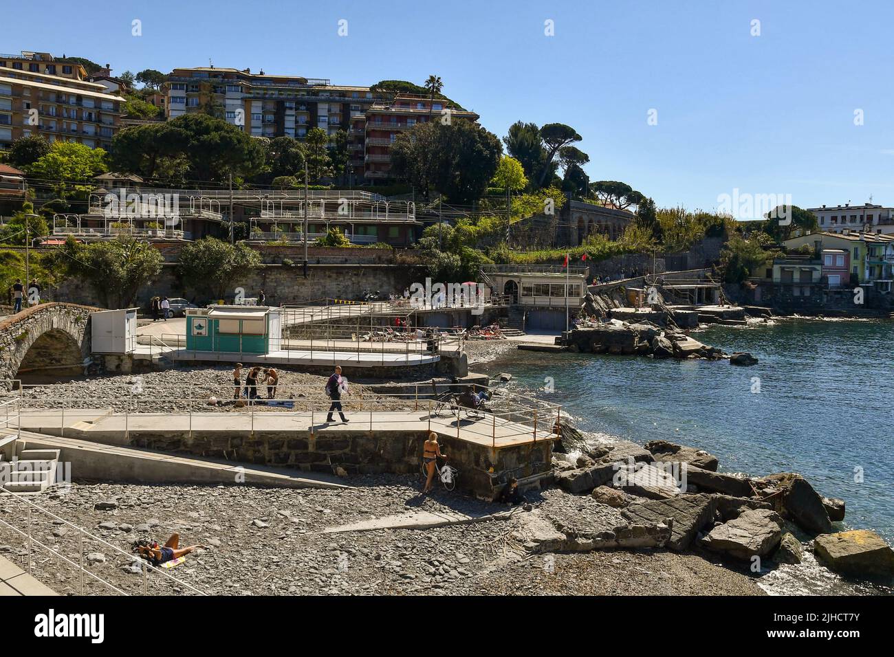 View of the promenade with people sunbathing on the pebble beach in a ...