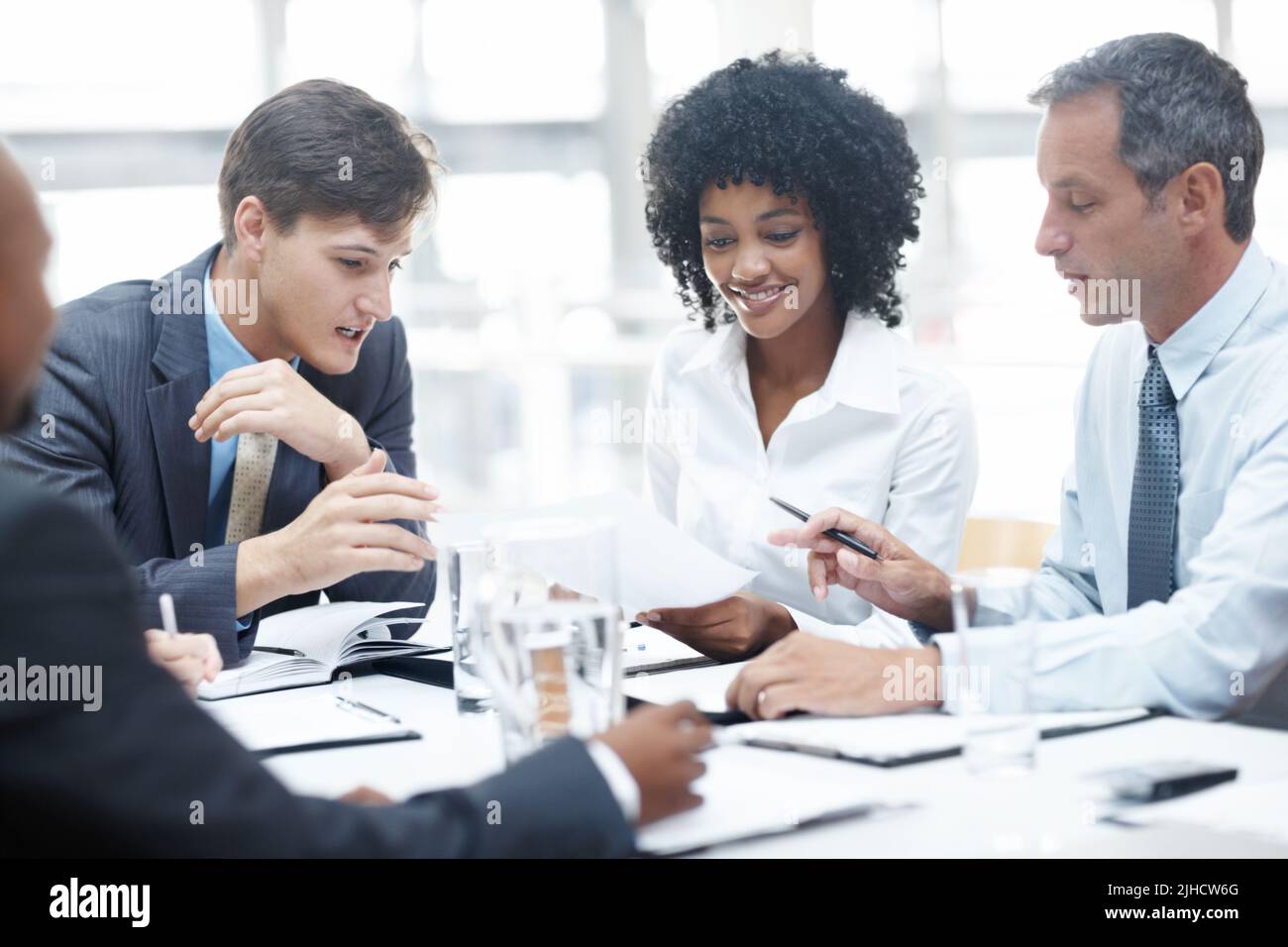 Going over the numbers. A diverse group of business people looking over ...