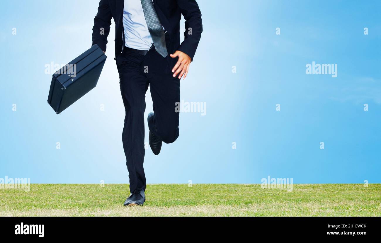 Male business executive running with a briefcase on a field. Cropped ...