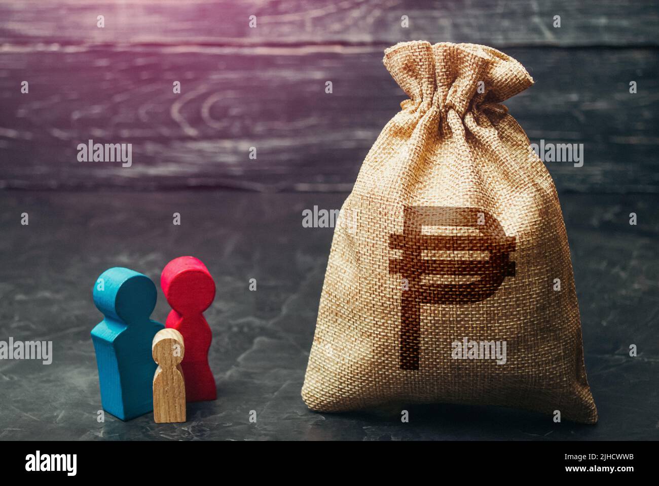 Family figurines and philippine peso money bag. Social assistance and ...