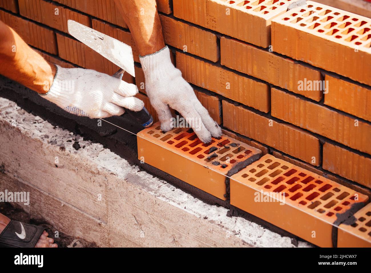 Builder laying bricks on construction site Stock Photo - Alamy
