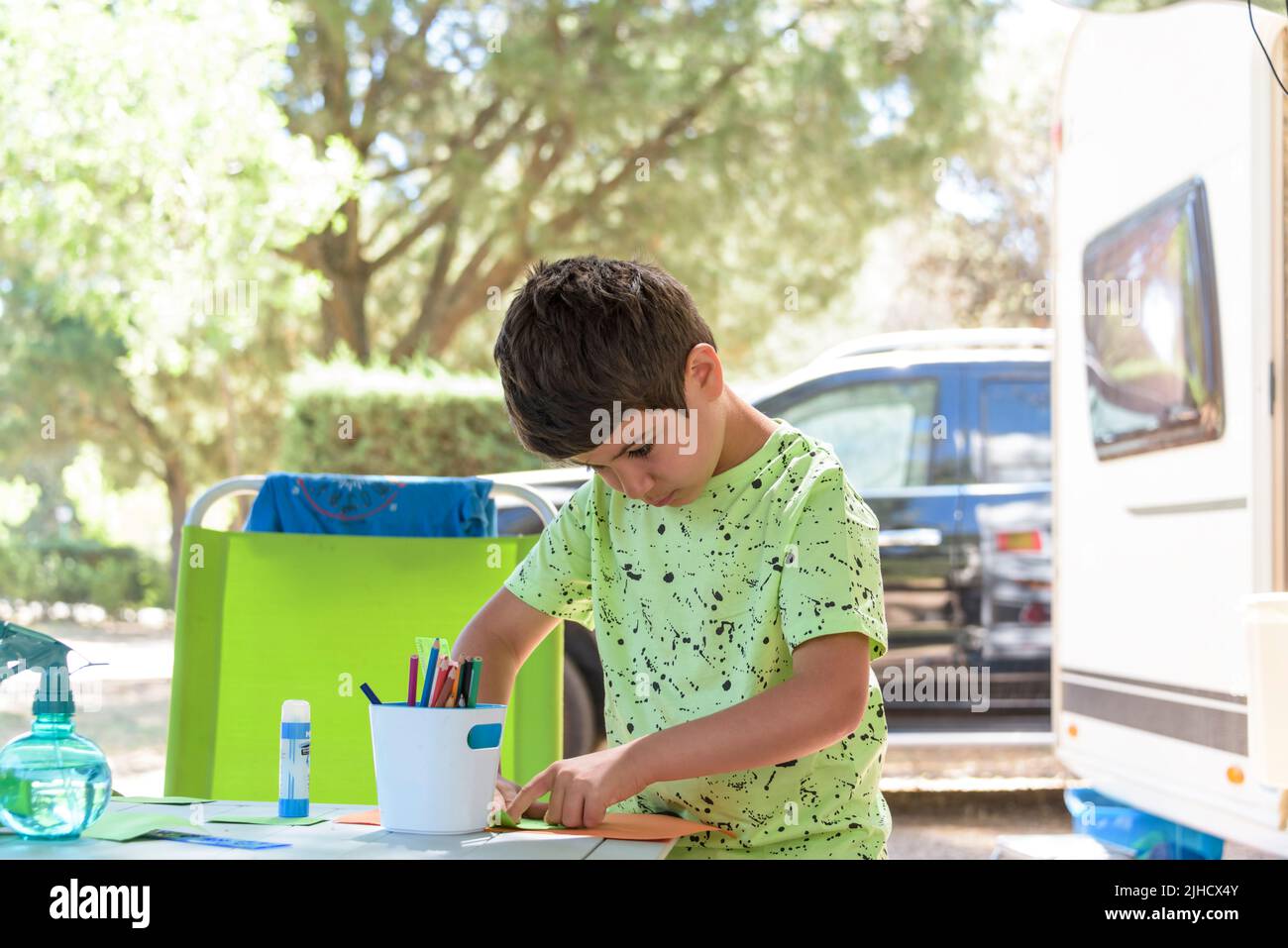 Primary school boy doing manual work while on vacation and preparing to ...