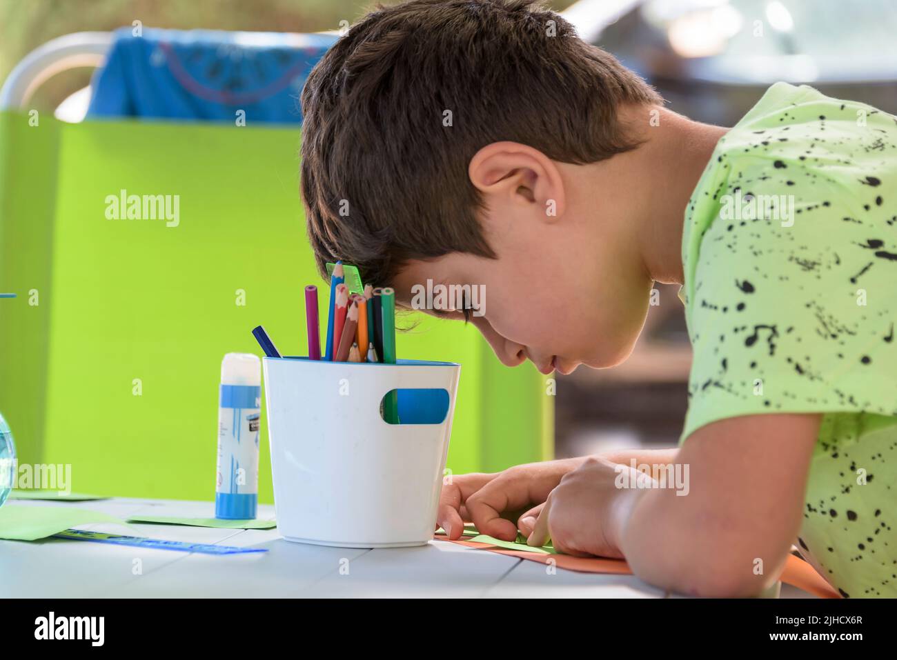 Primary school boy doing manual work while on vacation and preparing to ...