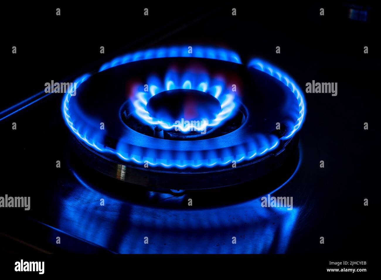 Gas cooktop burning gas stove with blue flame Stock Photo - Alamy