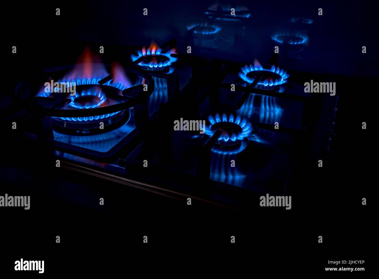 Gas cooktop burning gas stove with blue flame Stock Photo - Alamy