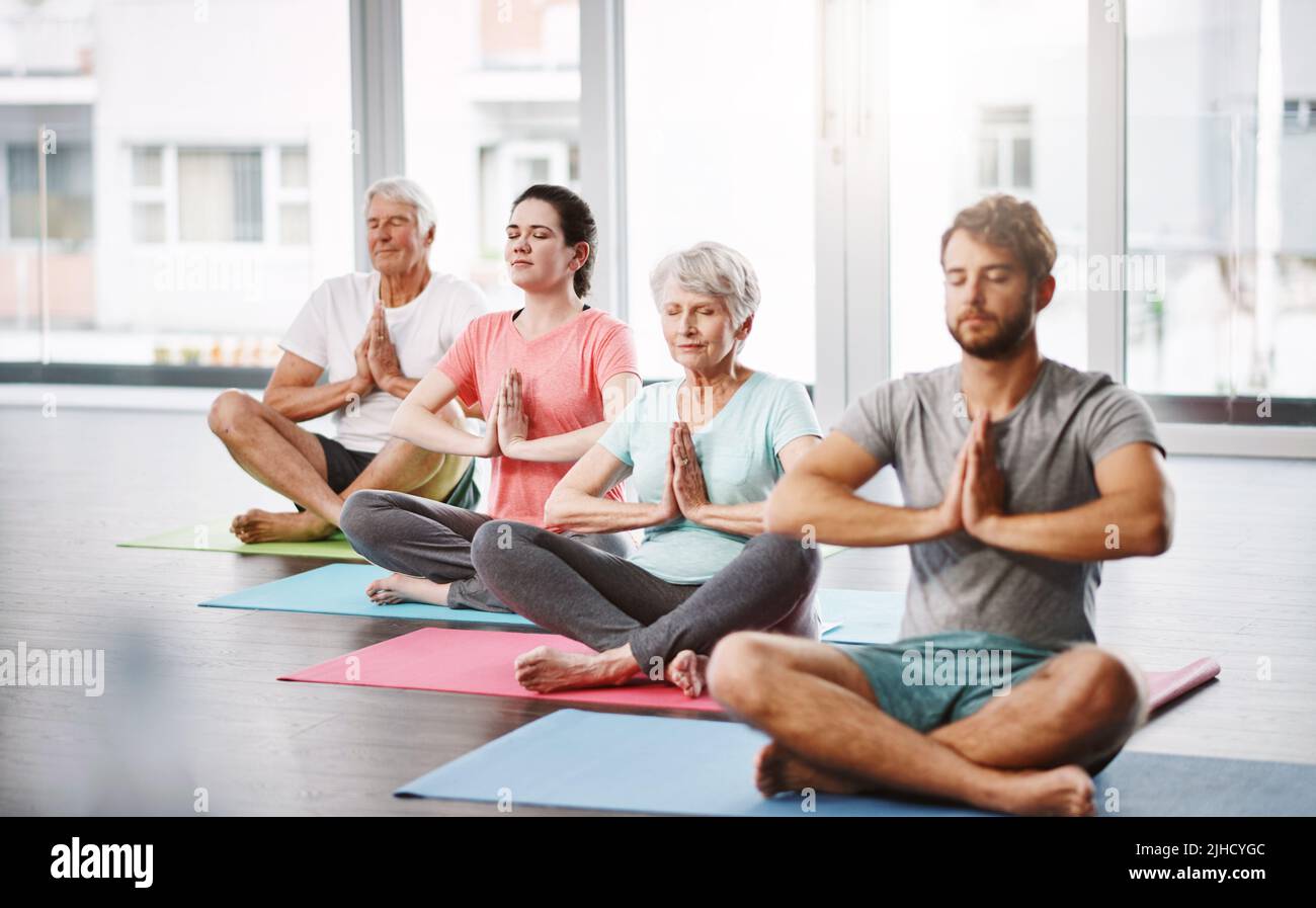 Exploring their minds. Full length shot of a group of people meditating ...