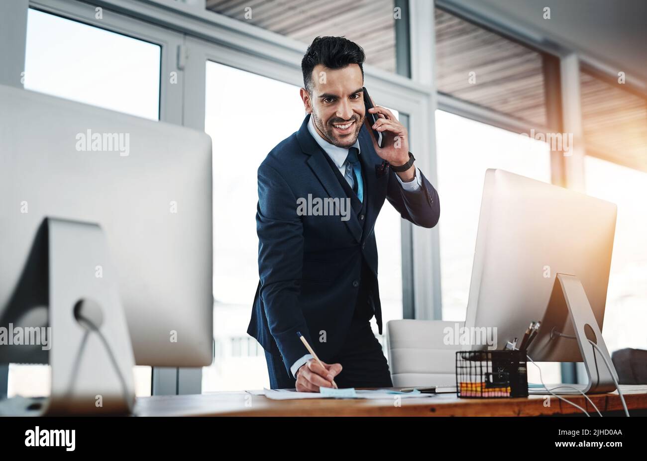 Working hard for his promotion. a handsome male executive working in a ...