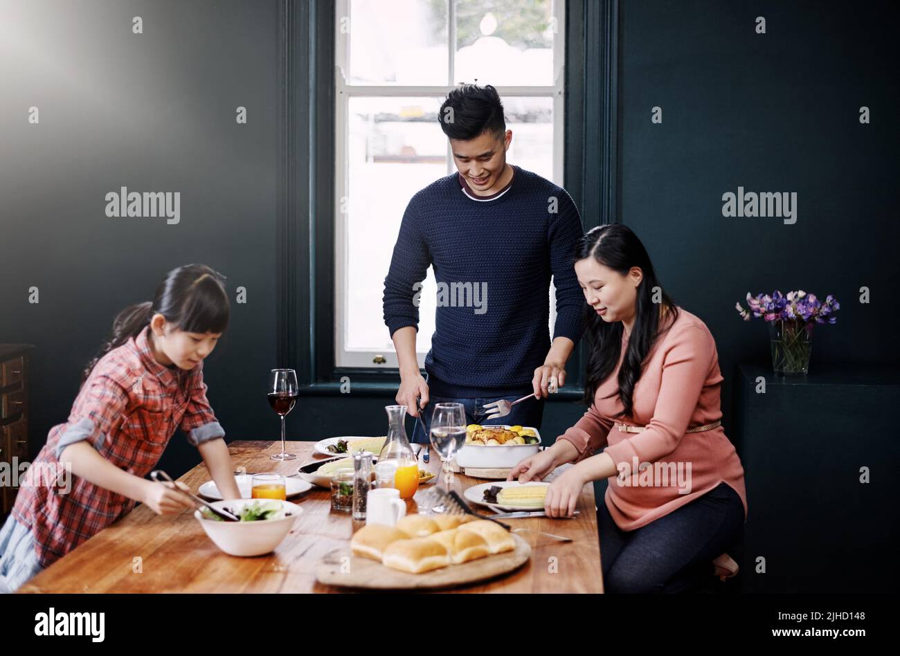 Make time to have dinner together as a family. a young family having a ...