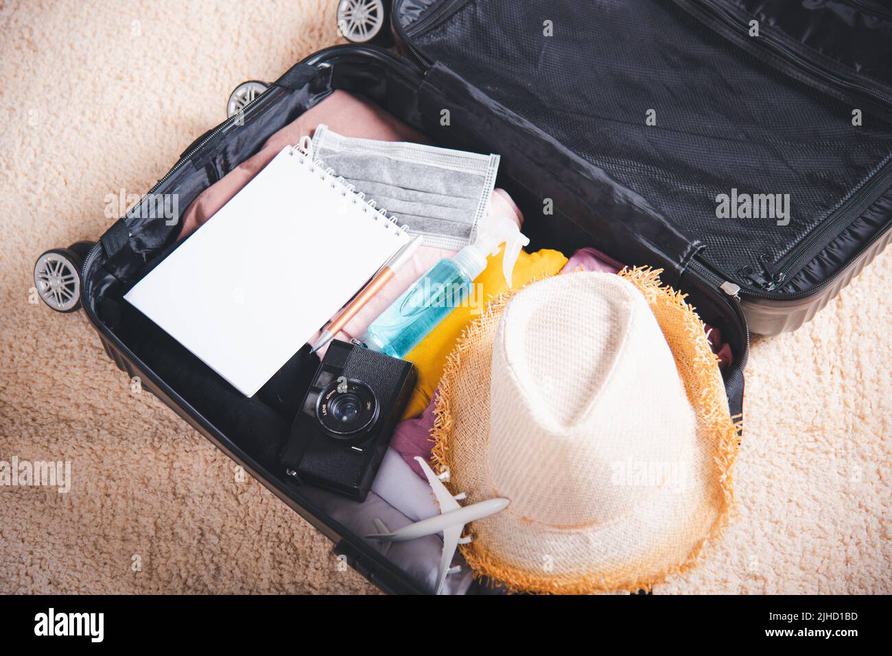 Open suitcase with traveler belongings clothes and accessories of ...