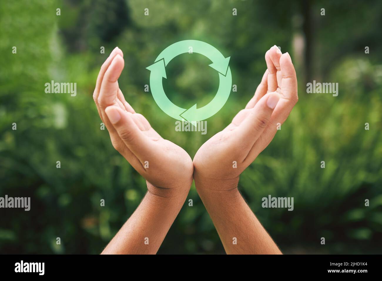 Hands supporting a digital recycle symbol. Someone protecting the ...