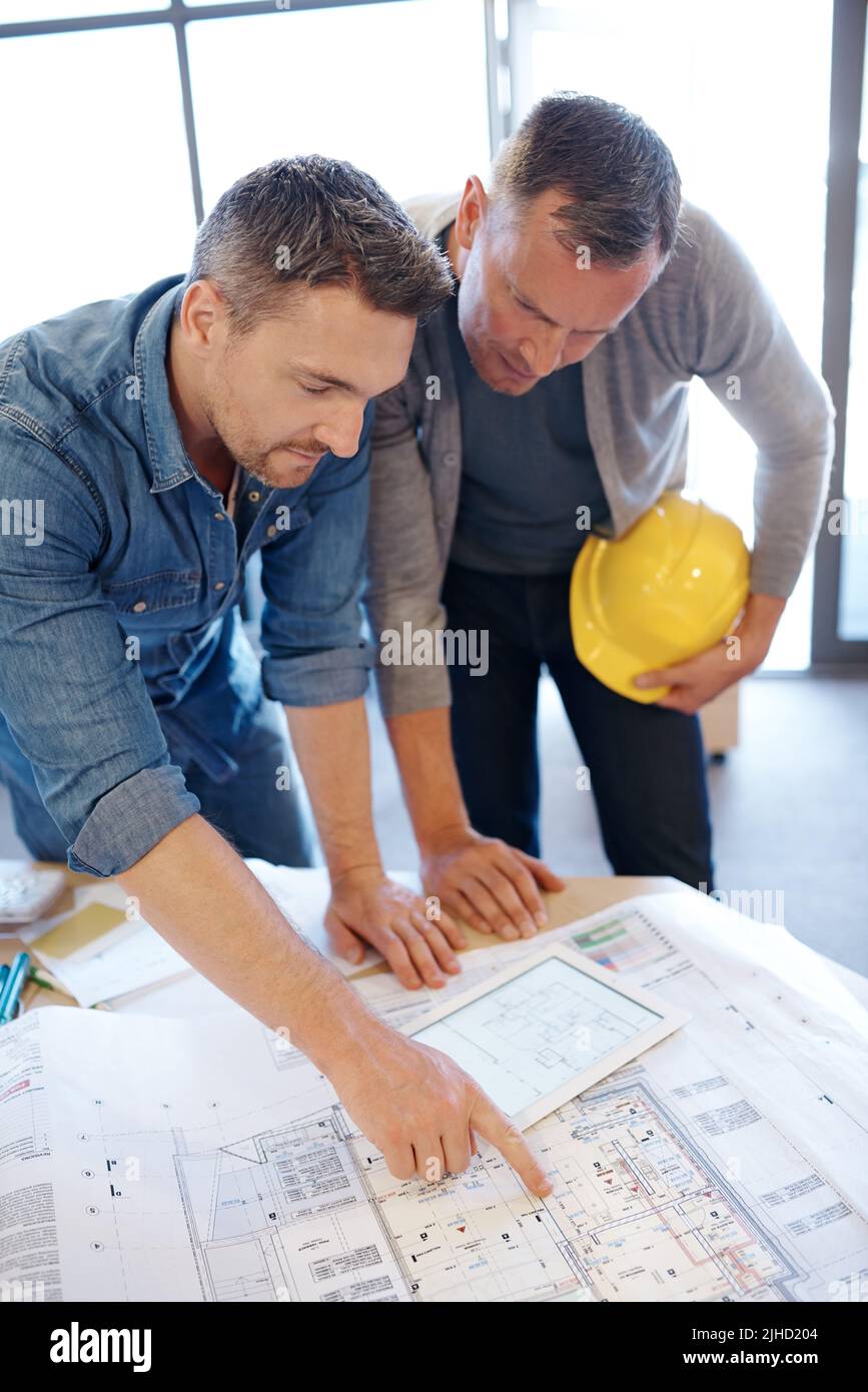 Plans in progress. two architects working together on a blueprint with ...