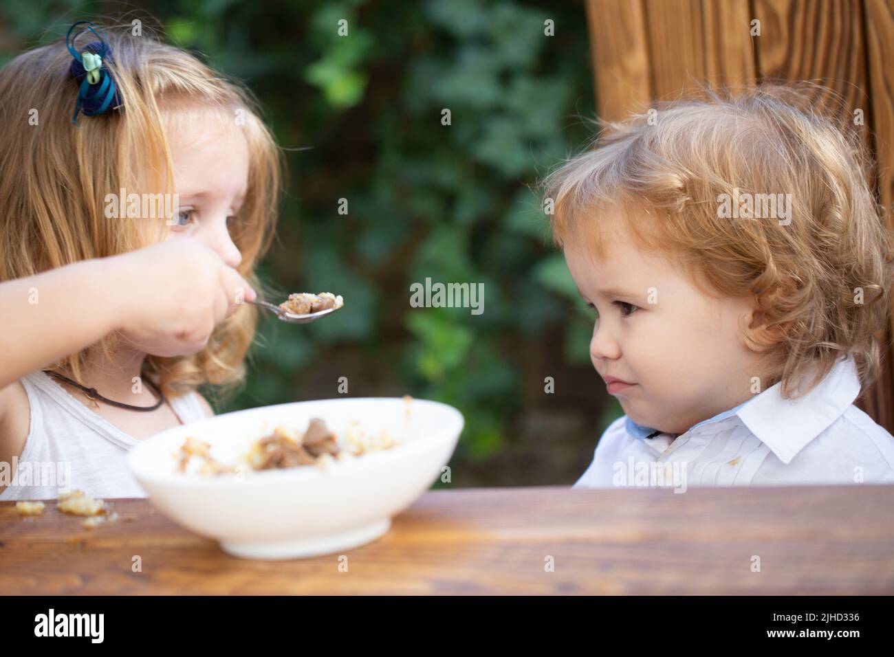 Little girl sister feeding baby. Cute baby food, babies eating Stock ...