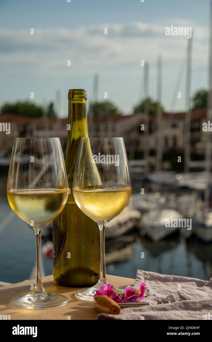 Drinking of cold white wine with view on yacht harbour of Port Grimaud ...