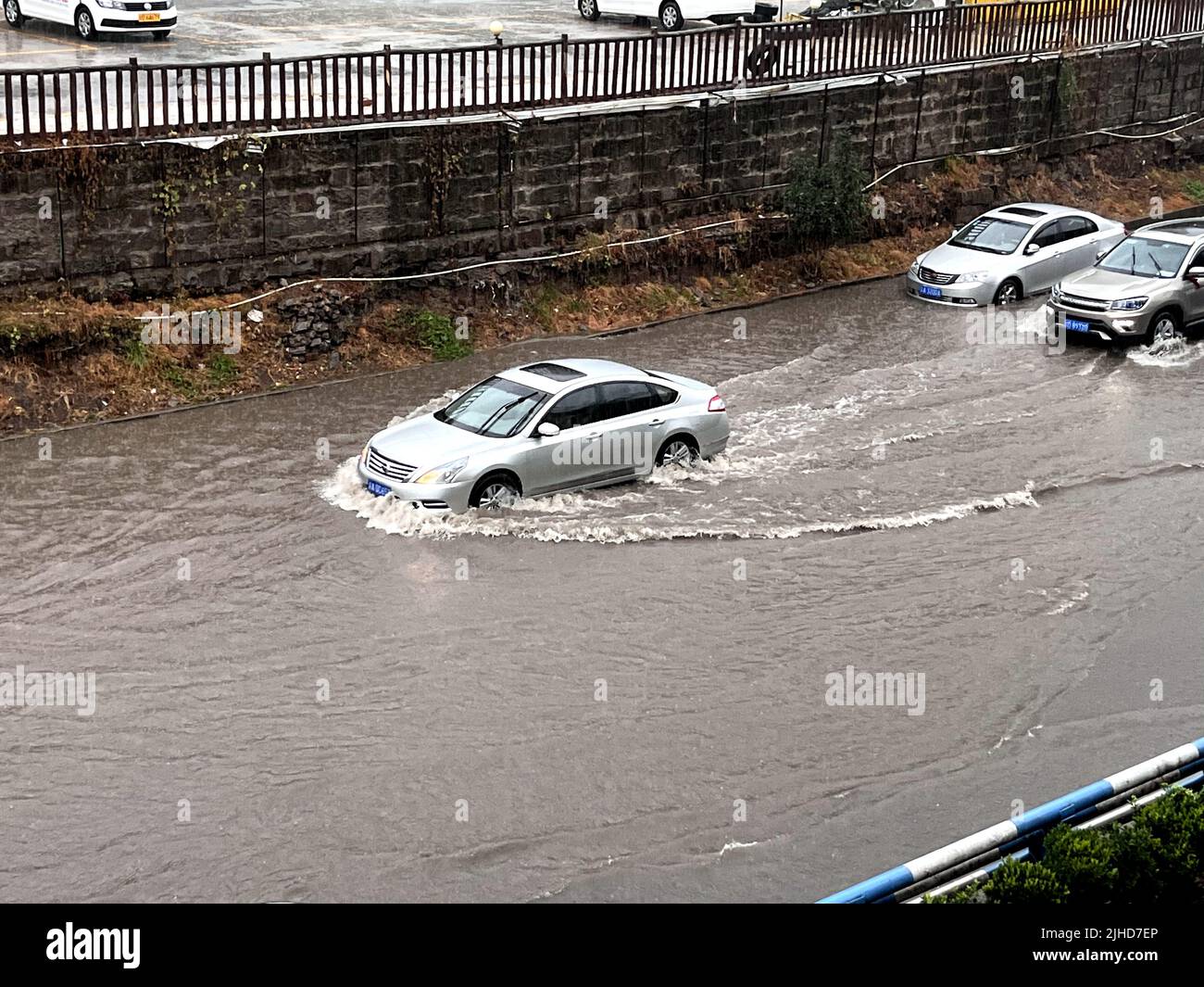 CHONGQING, CHINA - JULY 18, 2022 - Cars drive through water caused by ...