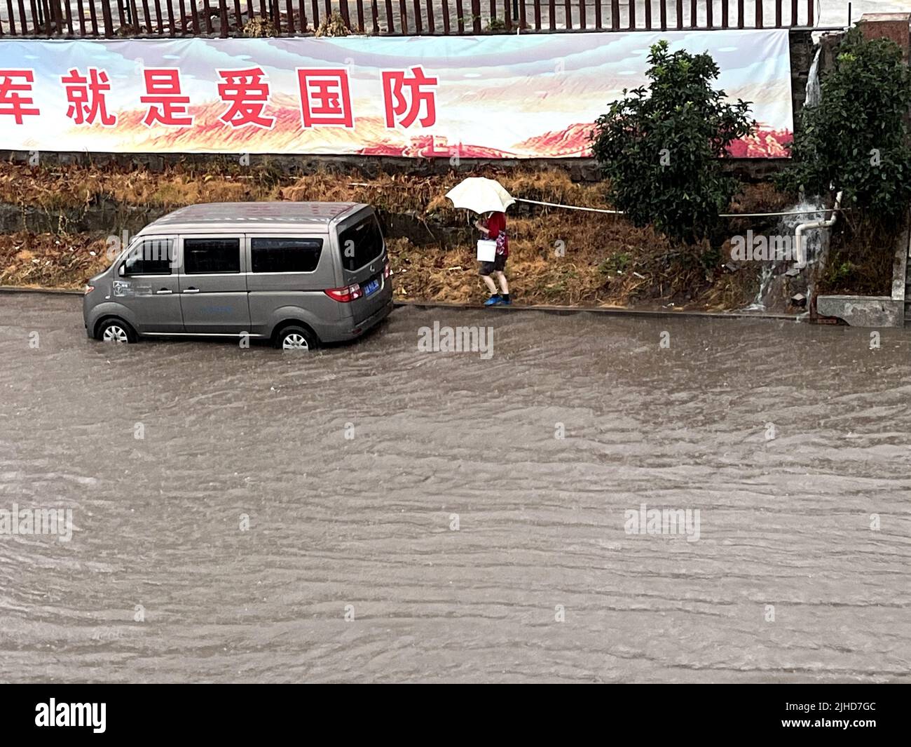 CHONGQING, CHINA - JULY 18, 2022 - Cars drive through water caused by ...