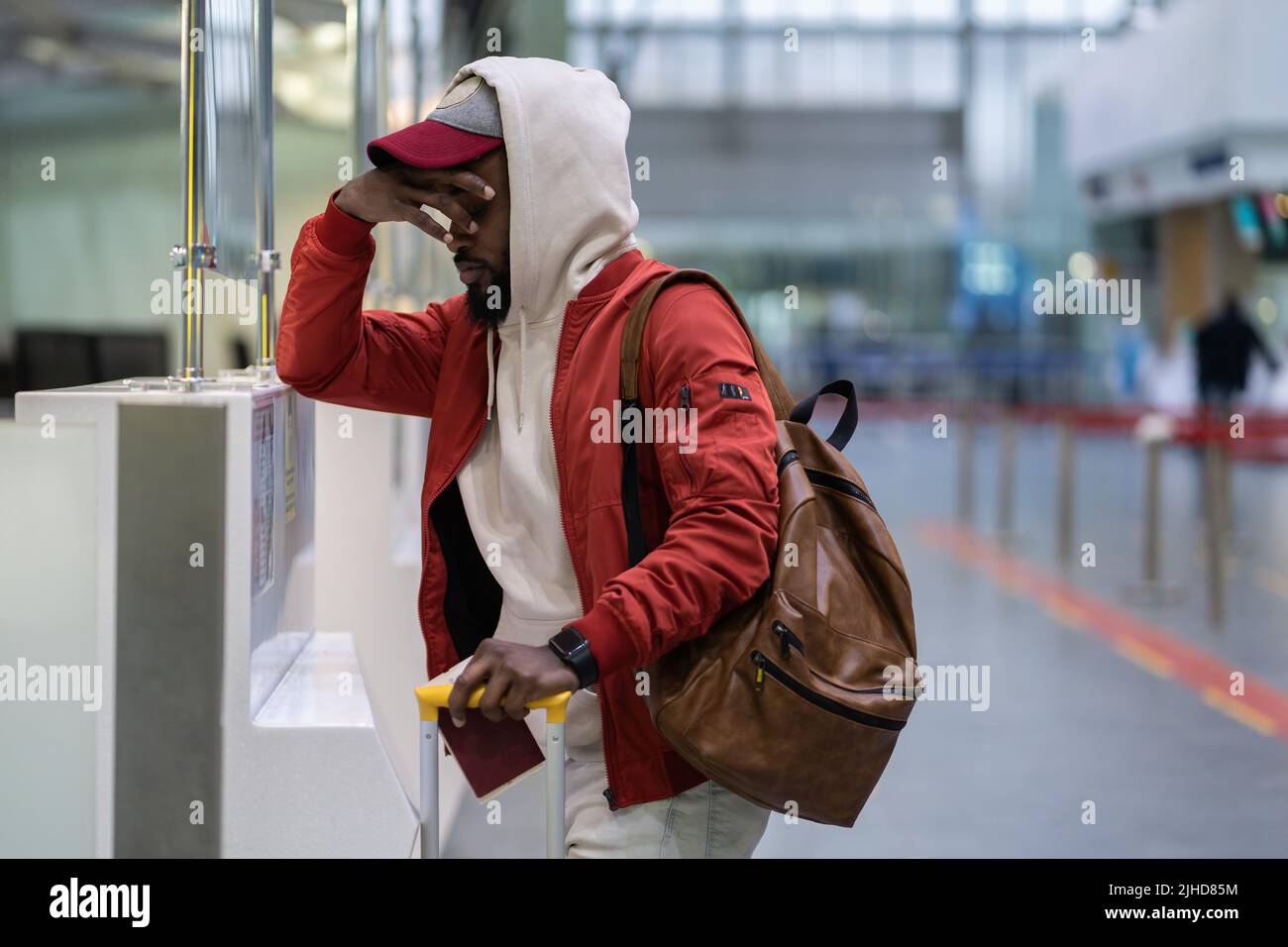 Frustrated disappointed African American male passenger with luggage ...