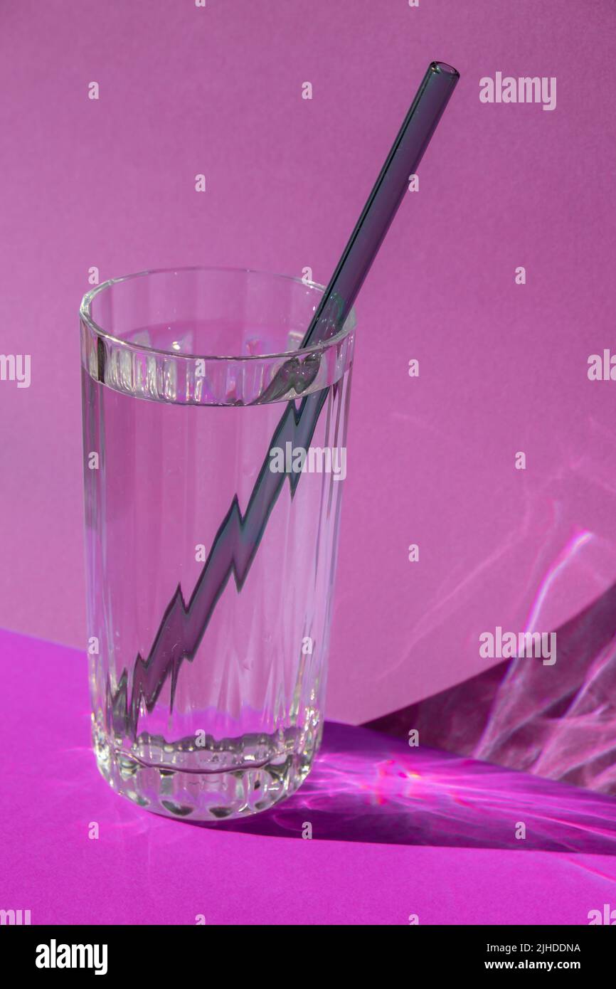 Reusable glass Straws in Glass with water on purple violet background ...