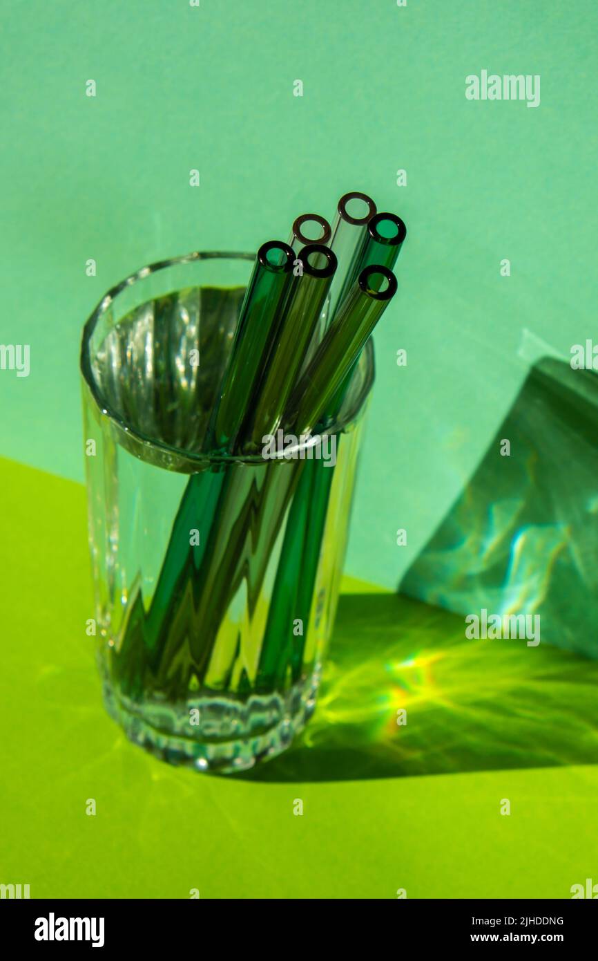 Reusable glass Straws in Glass with water on green background Eco ...