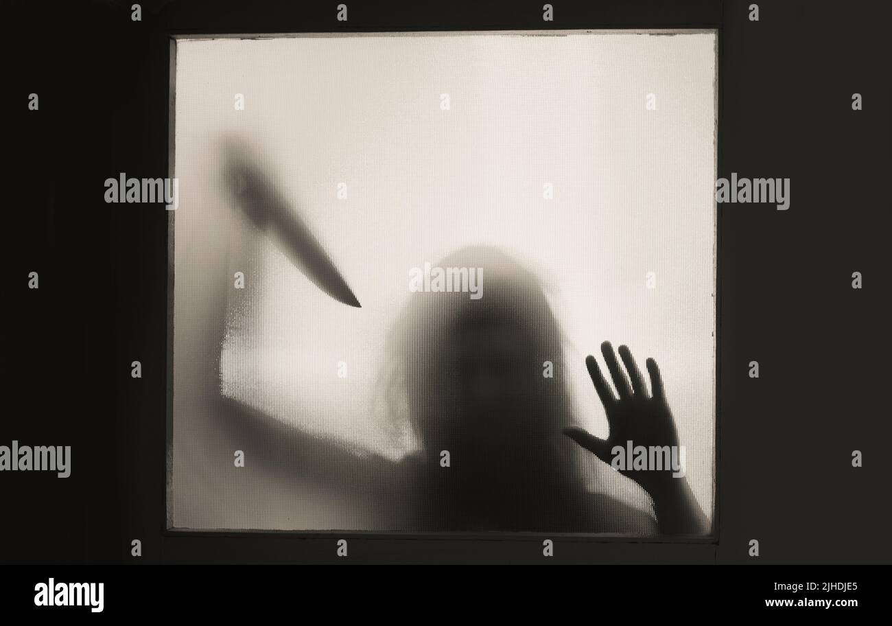Horror, halloween background - Shadowy figure behind glass holding a ...