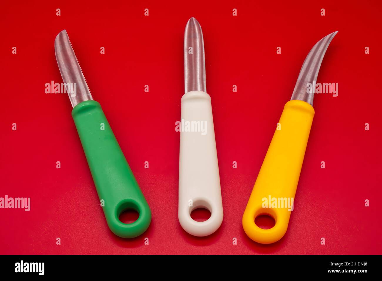 Knives of different shapes isolated on red background Stock Photo - Alamy
