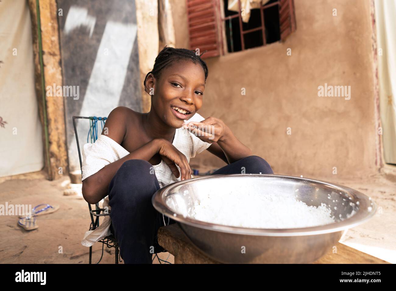 Beautiful African girl enjoying her simple rice meal; symbol of ...