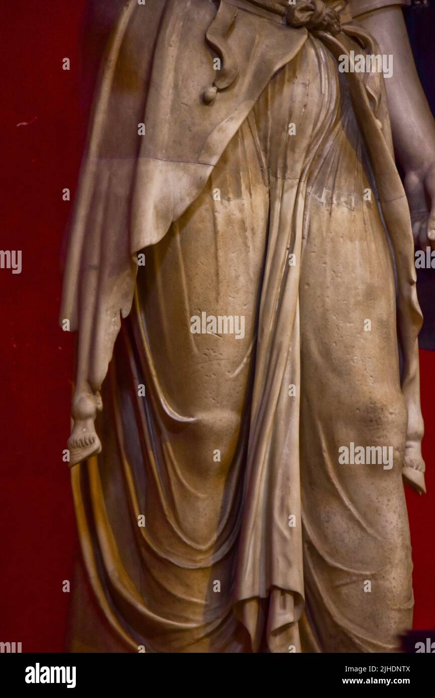 The vertical partial view of the dress of an antique statue against the ...