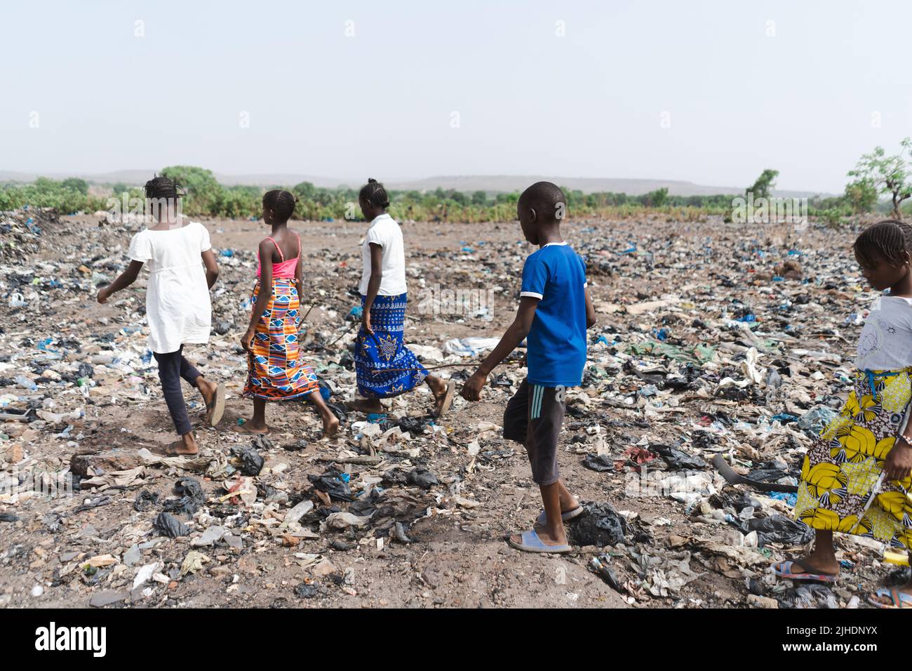 Slum children crossing a landfill; lack of infrastructure in developing ...