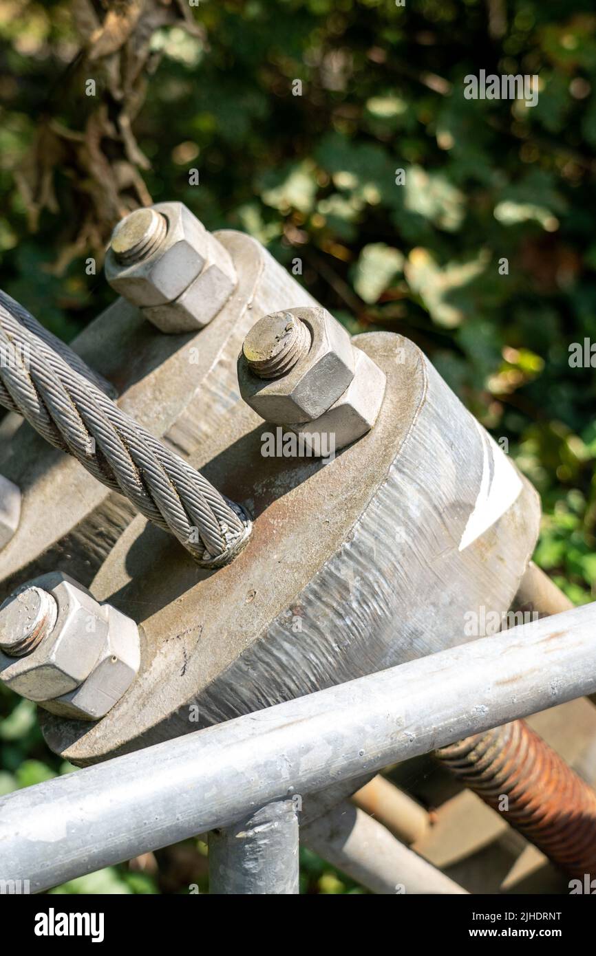 Bolt with a nut fastening the rope of a suspension bridge with a ...