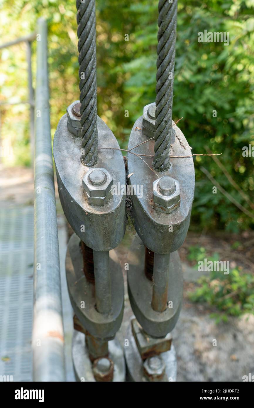Bolt with a nut fastening the rope of a suspension bridge with a ...