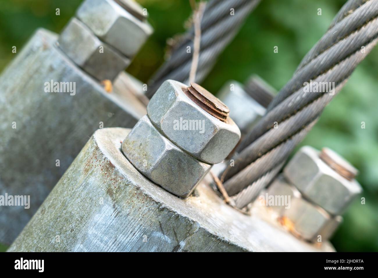 Bolt with a nut fastening the rope of a suspension bridge with a ...