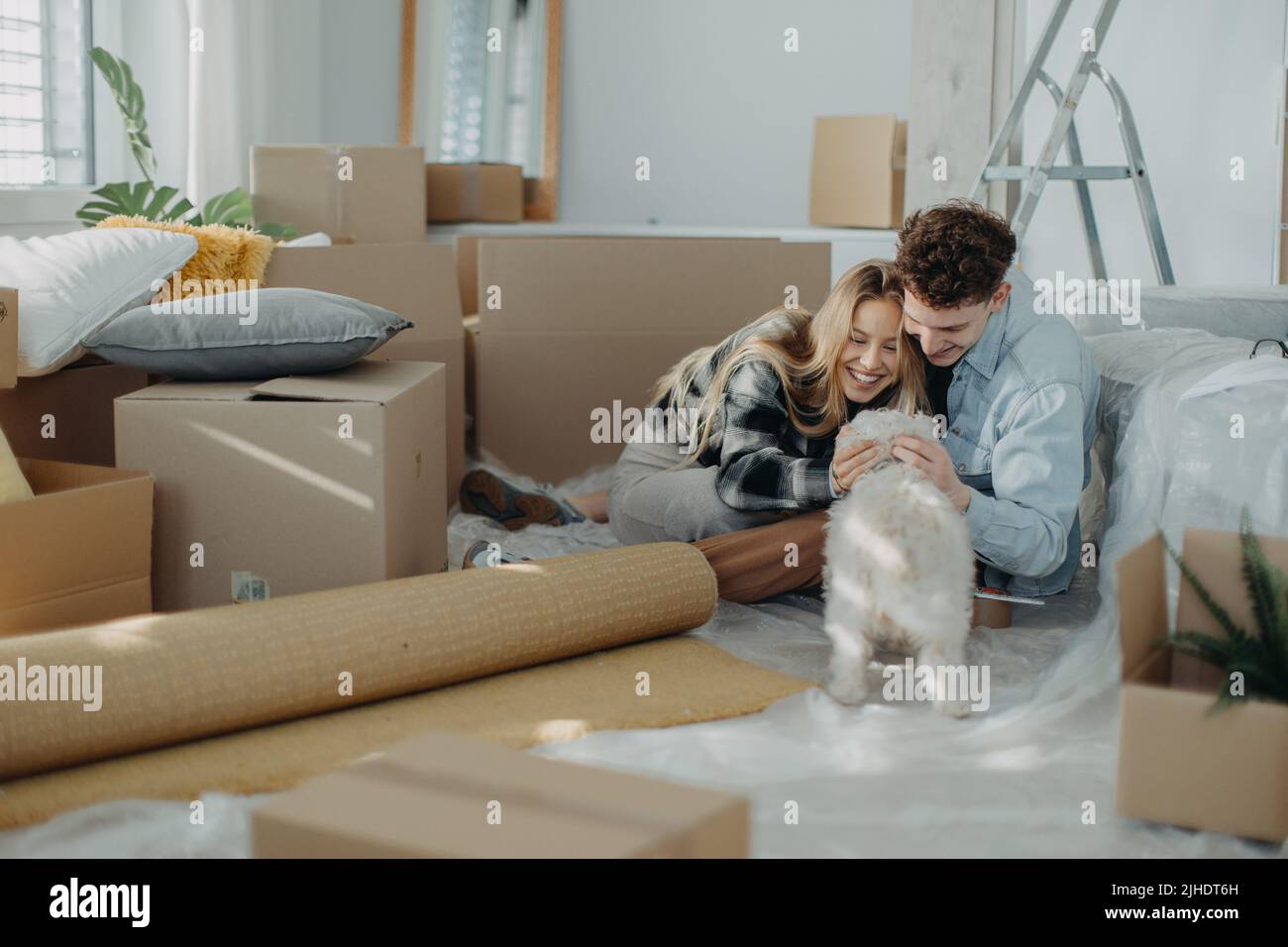 Cheerful young couple in their new apartment. Conception of moving ...