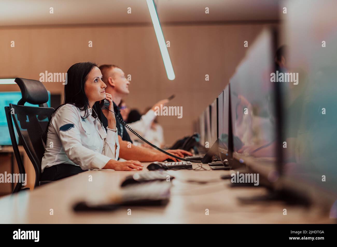 Female security guard operator talking on the phone while working at ...