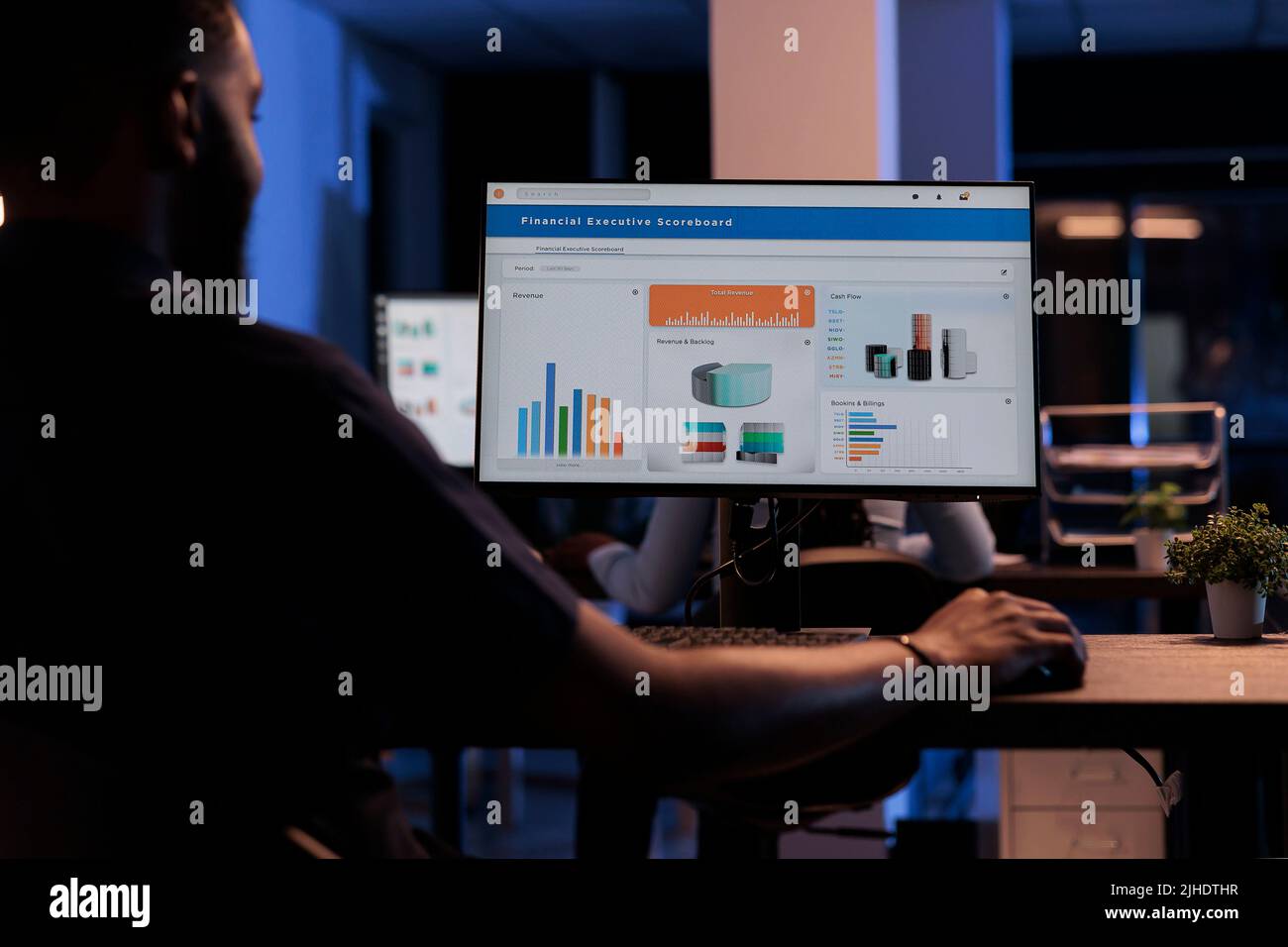 Young businessman looking at computer monitor with charts, analyzing ...