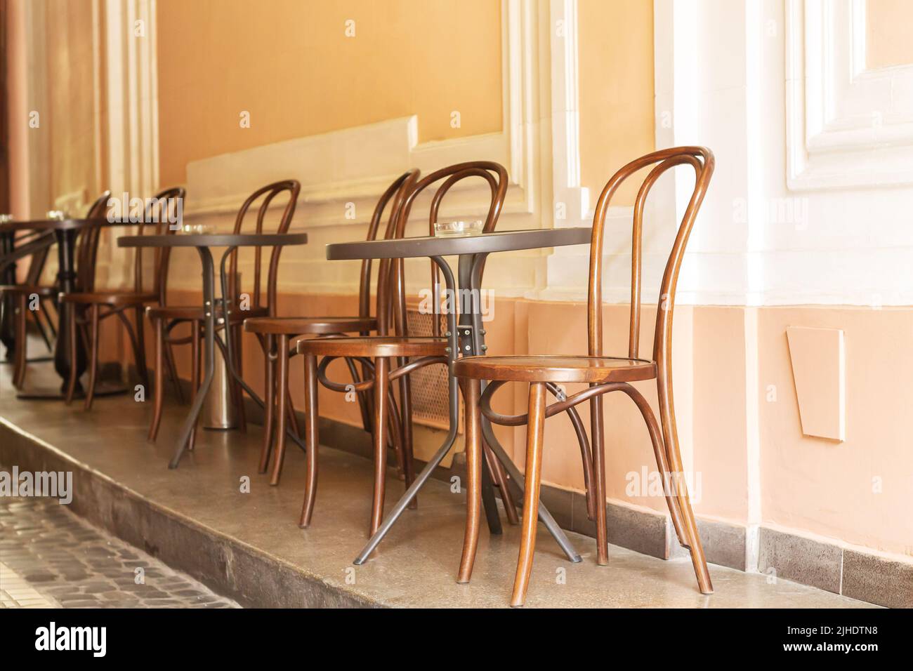 Vintage wooden round tables and chairs of sidewalk cafe Stock Photo - Alamy