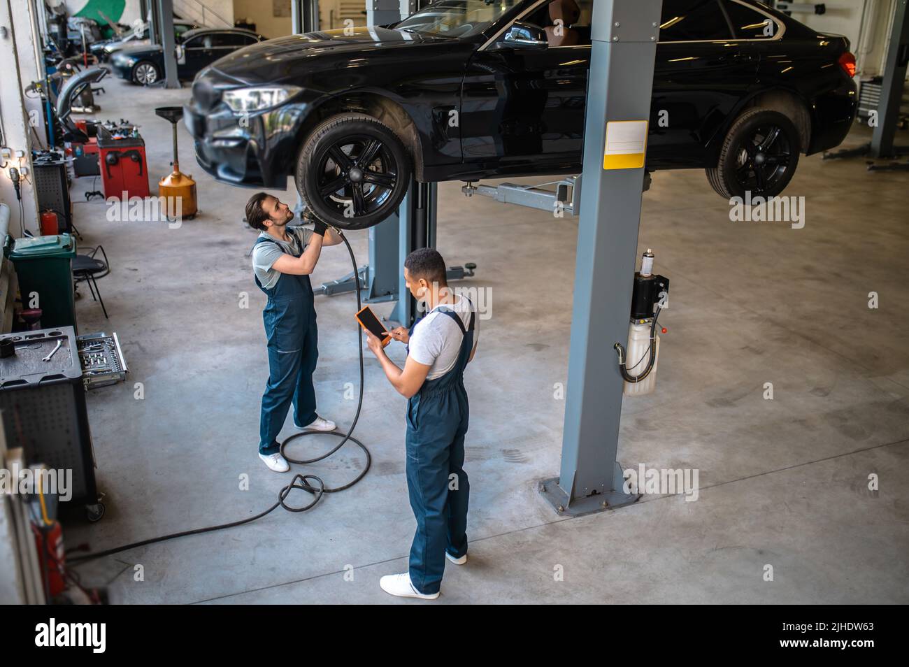 Two maintenance engineers at work in the garage Stock Photo - Alamy
