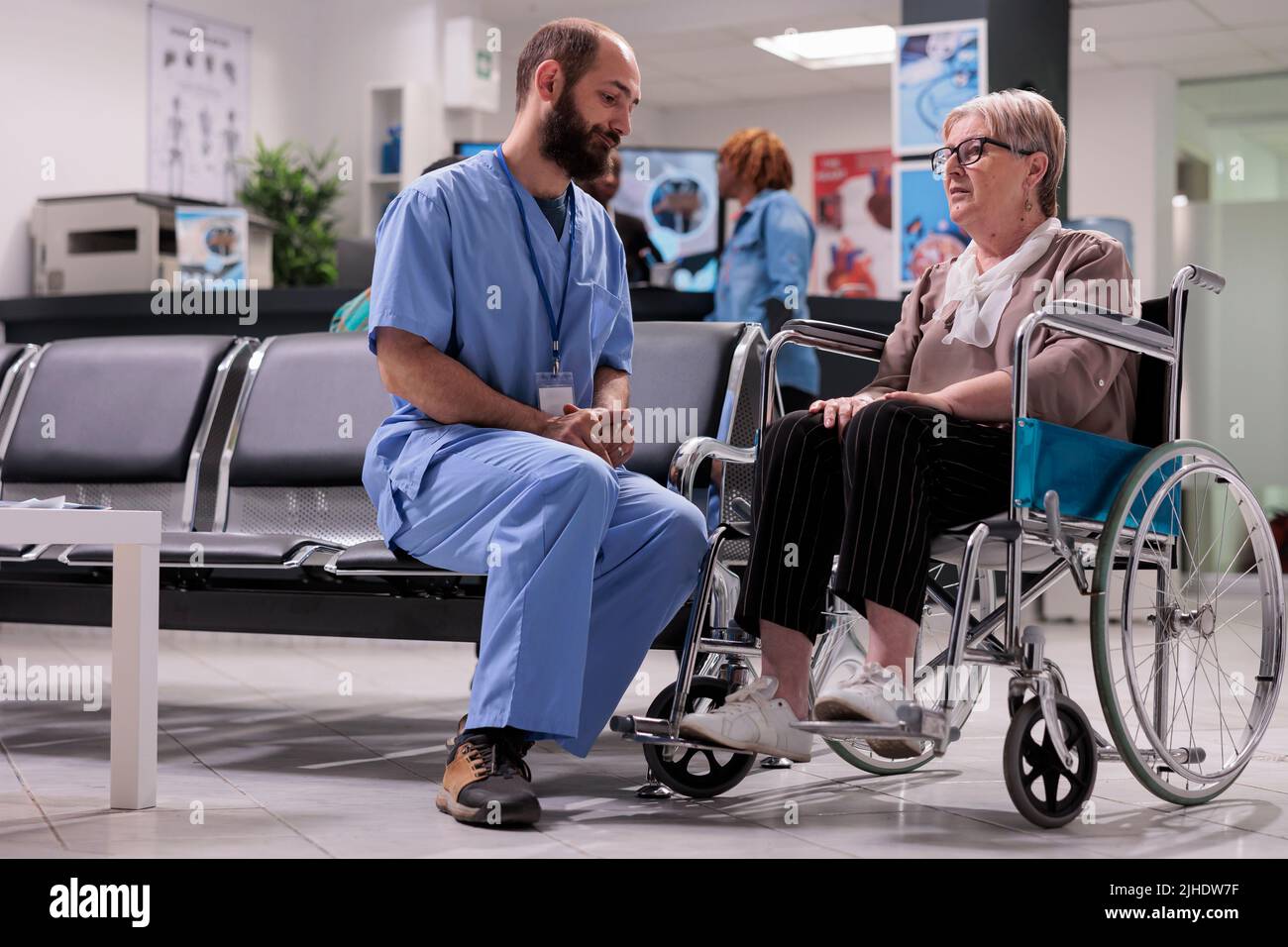 Male assistant consulting patient with chronic disability in hospital ...