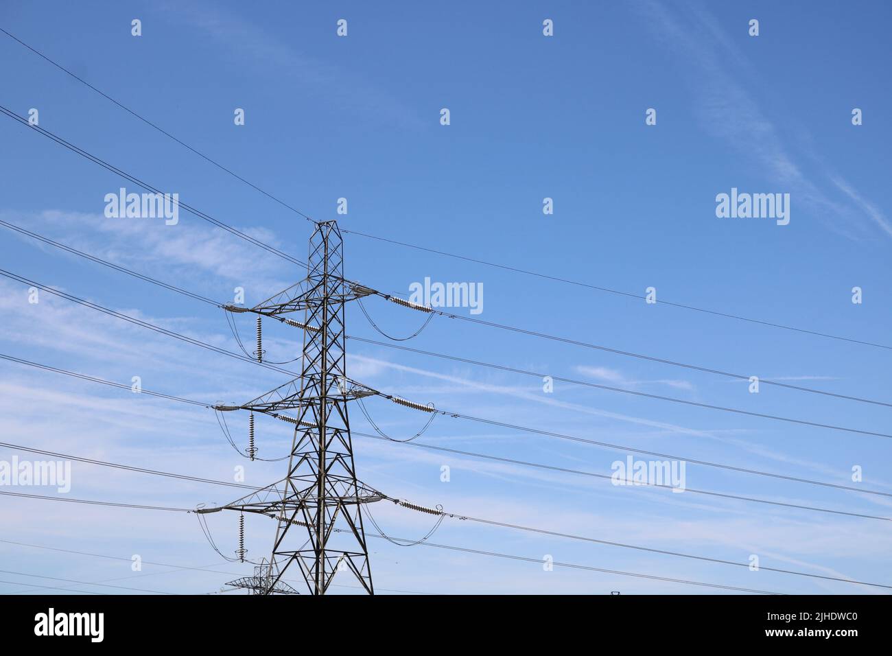 Electricity pylon and wires against blue sky with wispy clouds Stock ...