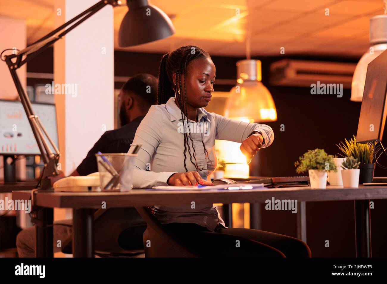 Woman checking clock office hi-res stock photography and images - Alamy