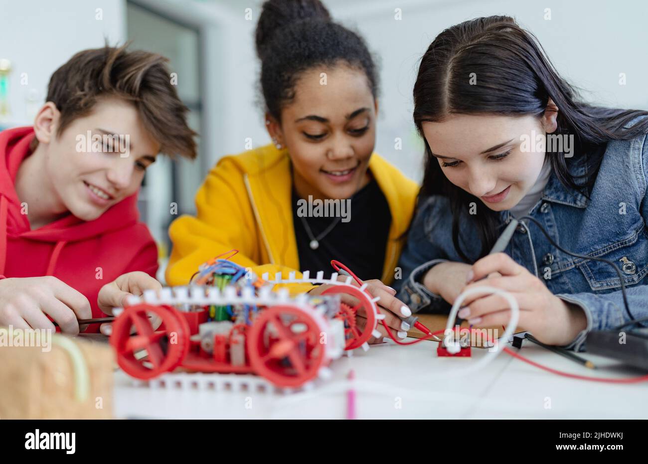 Group of high school students building and programming electric toys ...