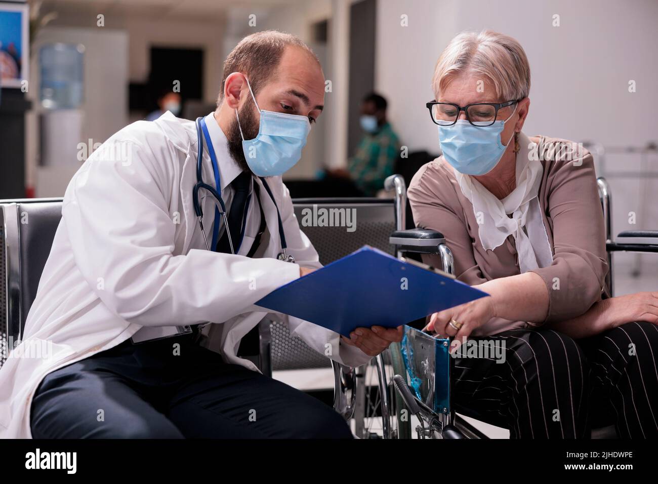 Physician talking to senior patient with chronic disability, consulting ...