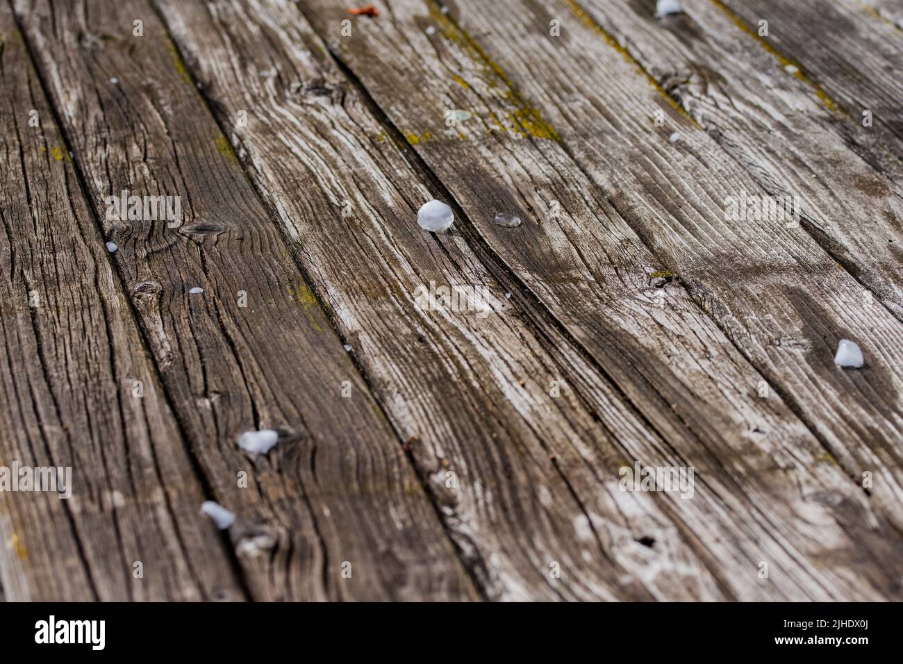 Small balls of hail, ice and hailstones from the sky on an old wooden ...