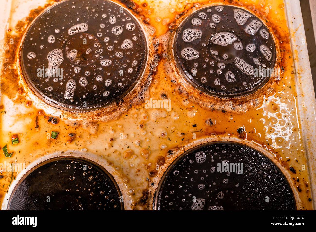 A very heavily soiled old electric kitchen stove in burnt brown soot ...