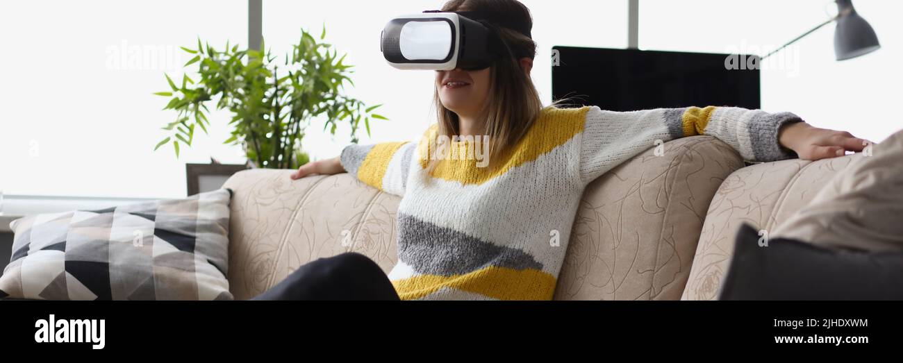 Female sit on couch wear vr glasses modern device at home and enjoy ...