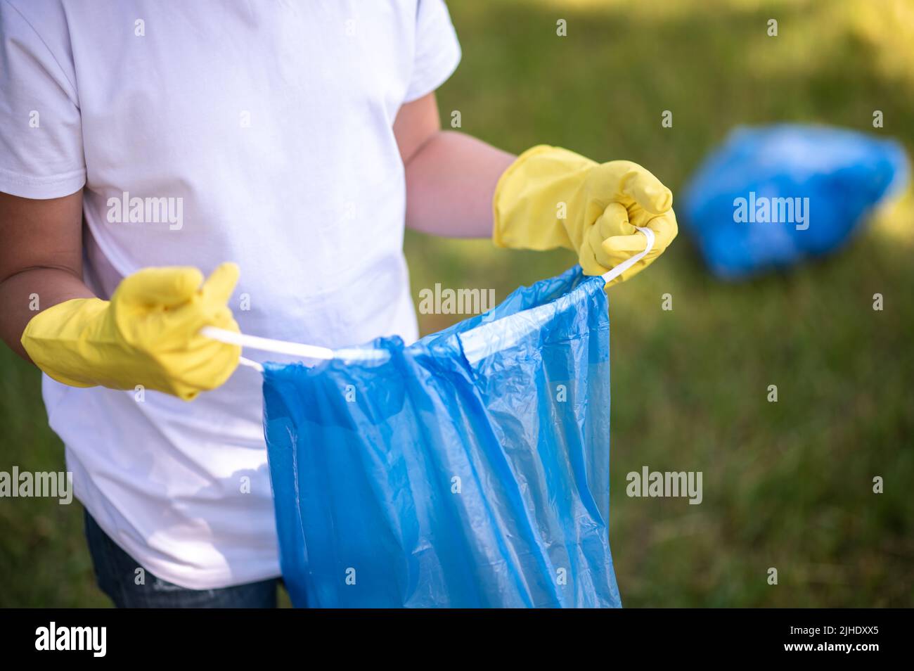 Close up of a kid holding a plastic bag for garbage Stock Photo - Alamy