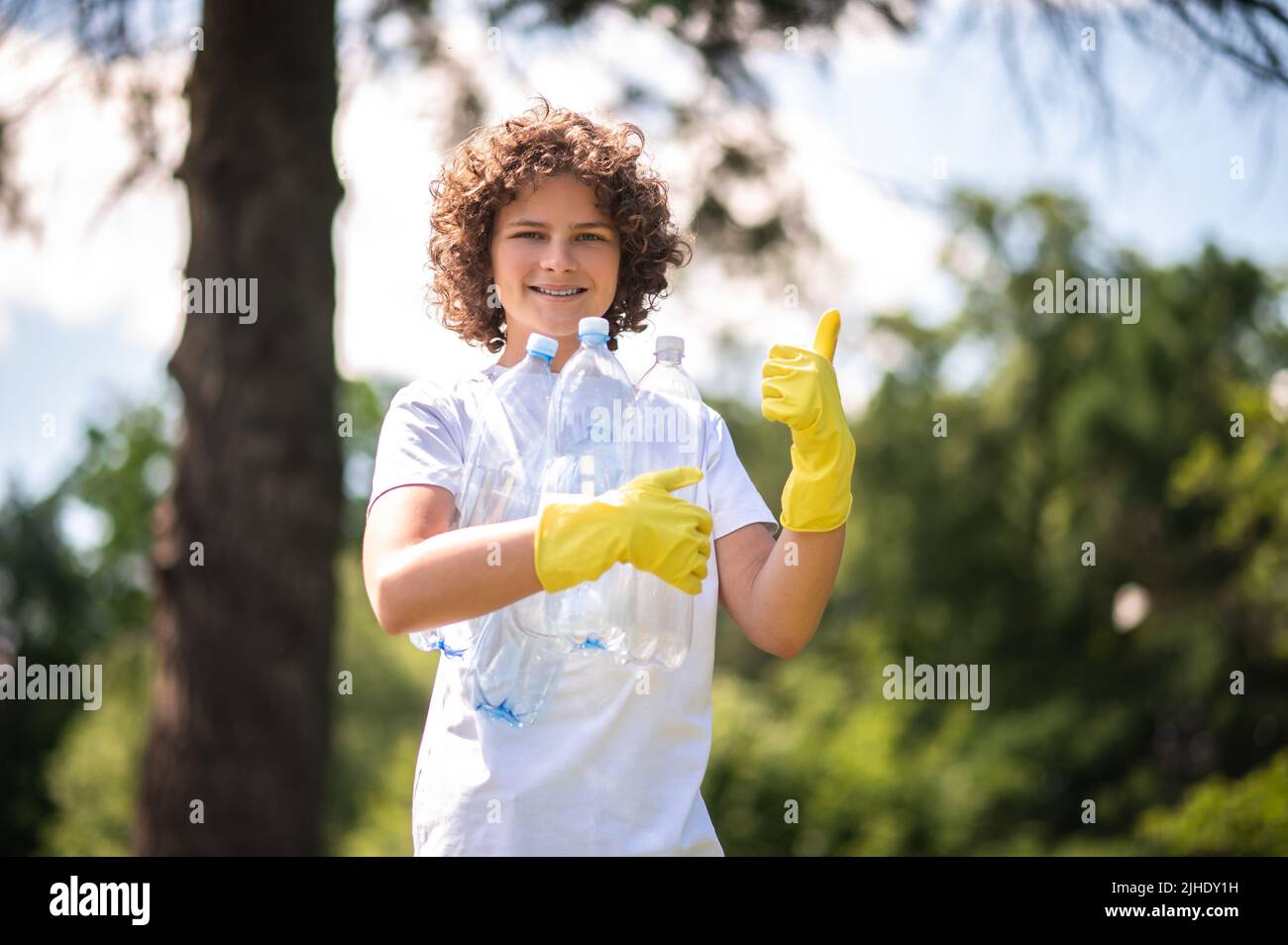 Smiling kid showing thumb up and looking contented Stock Photo - Alamy