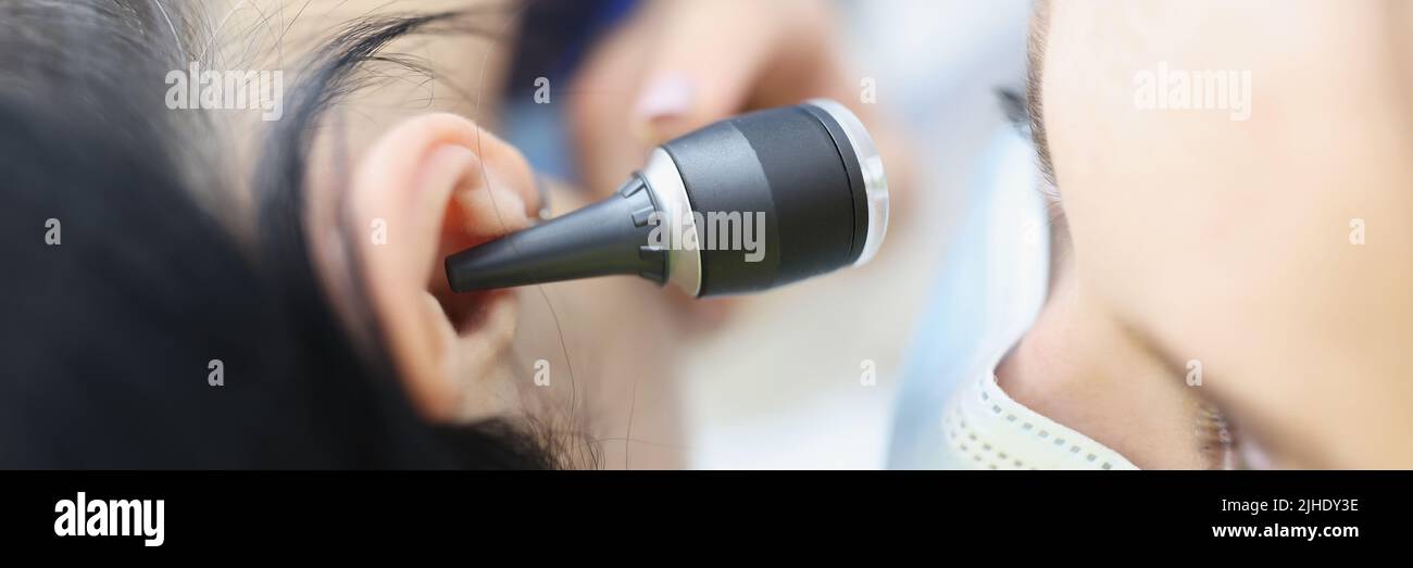 Doctor check patient on medical examination with special ear equipment ...